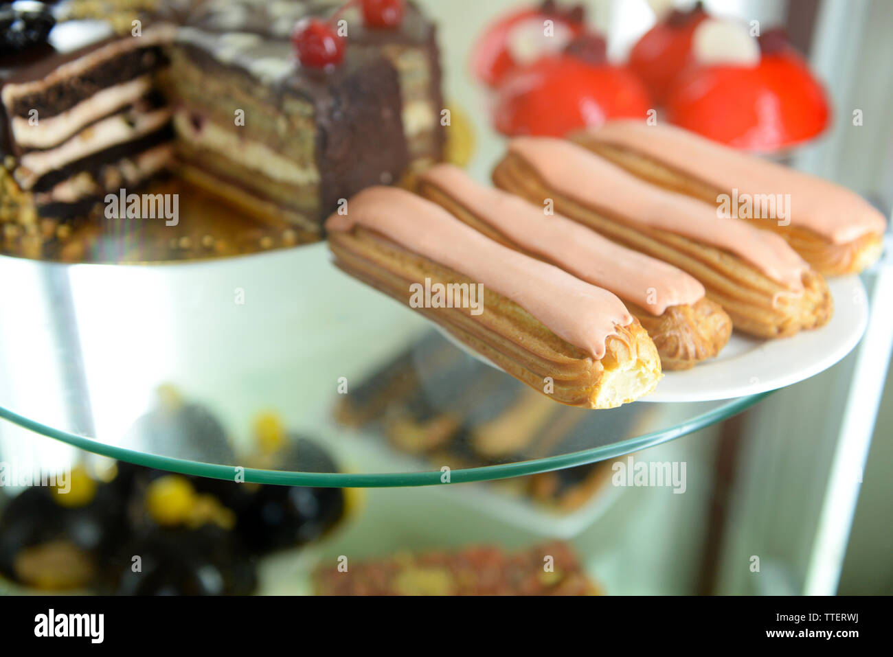 Delicious cakes on glass shelf in confectionery close up Stock Photo ...