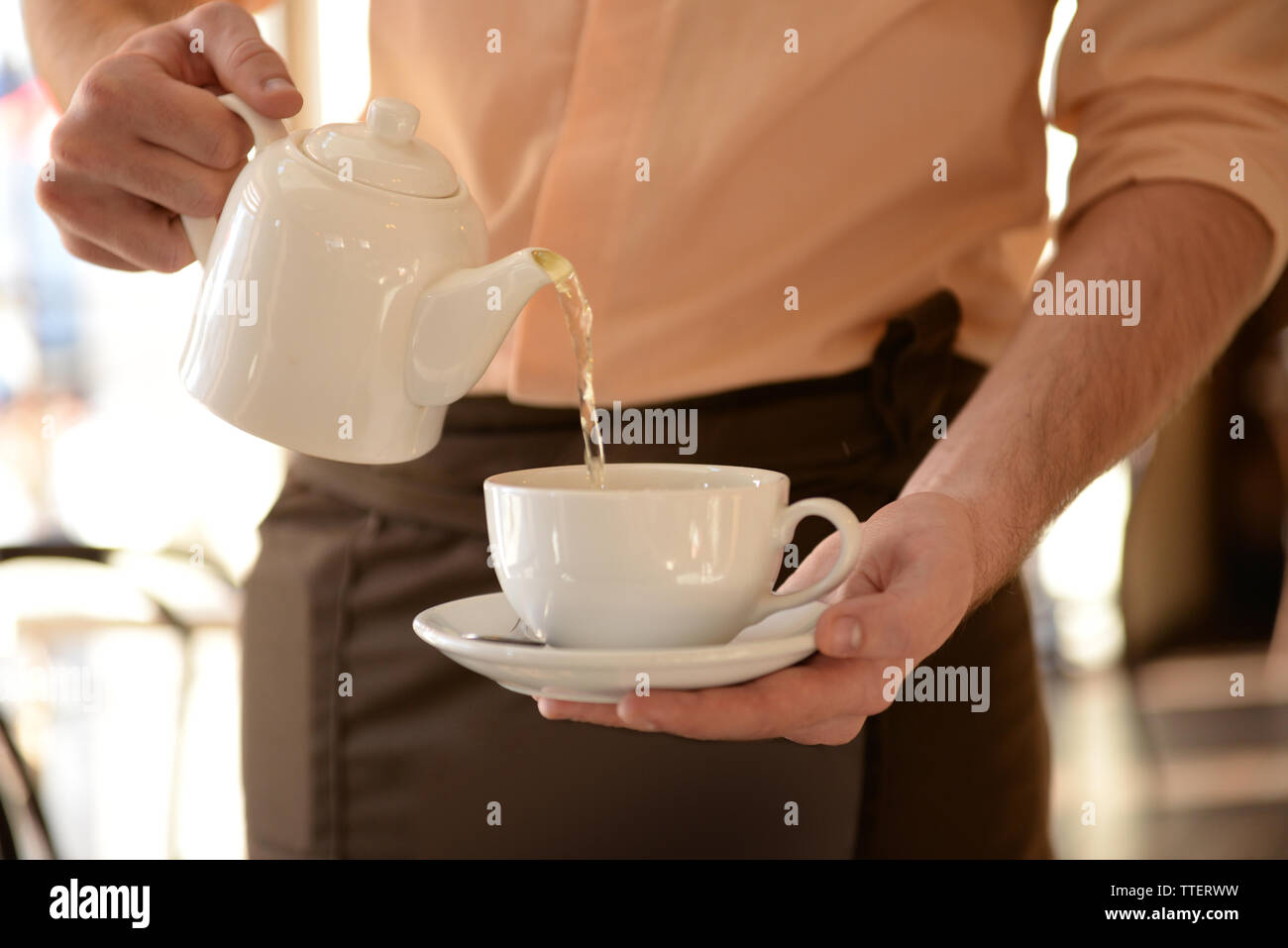 Waiter pouring tea into cup close up Stock Photo - Alamy