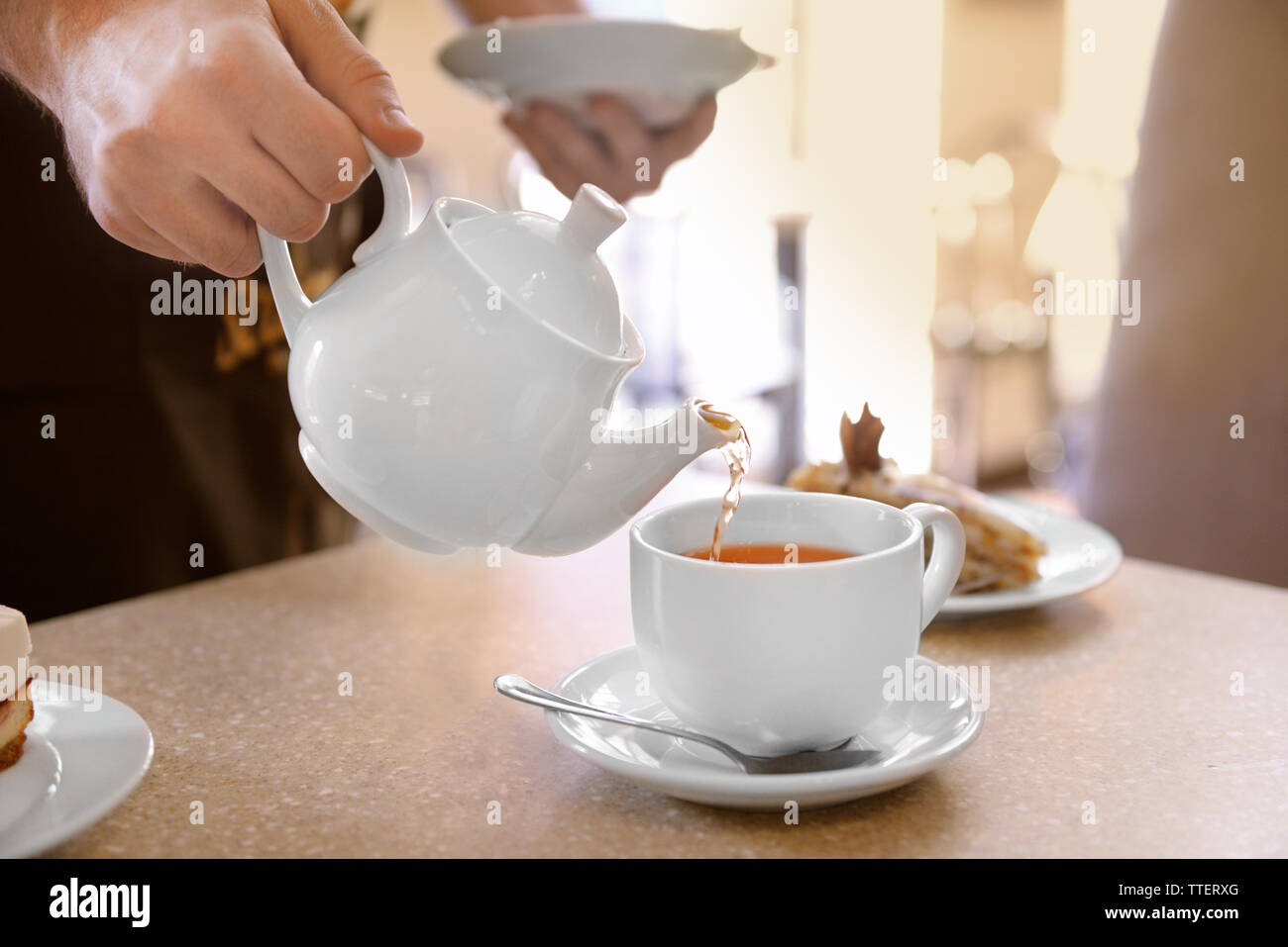 Waiter pouring hot tea teapot hi-res stock photography and images - Alamy