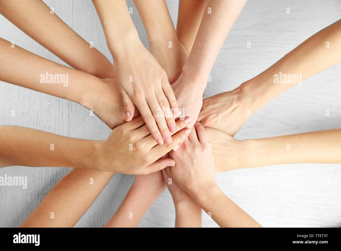 Group of people putting their hands together on wooden background Stock ...