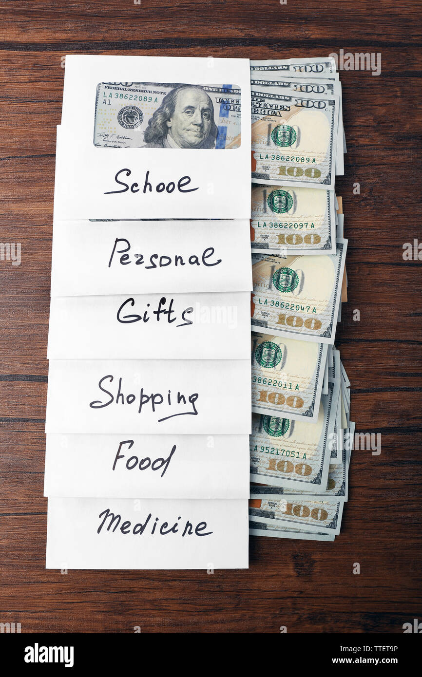 Distribution of money, financial planning, dollars in envelopes on ...