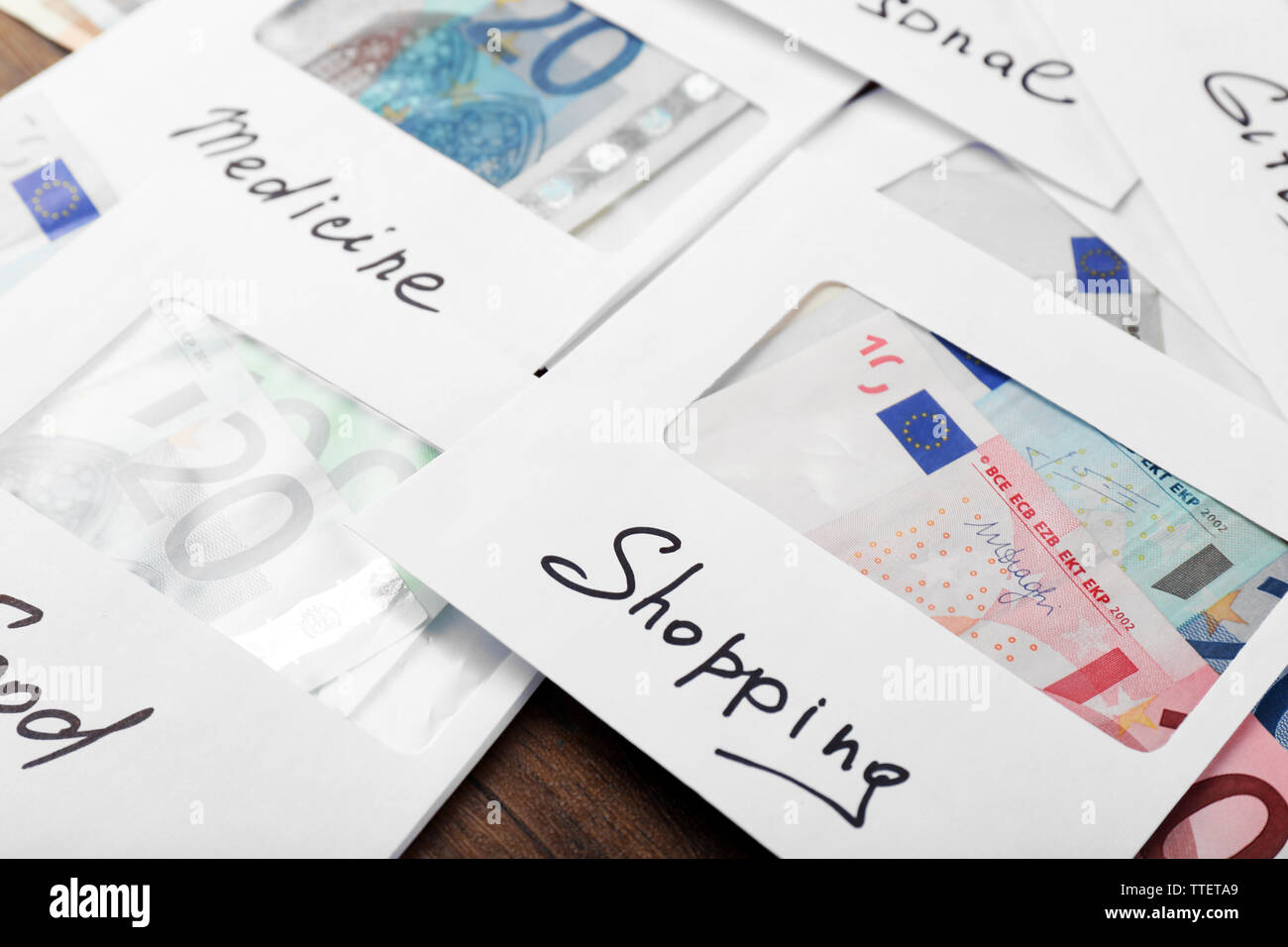 Distribution of money, financial planning, euro in envelopes, on wooden ...