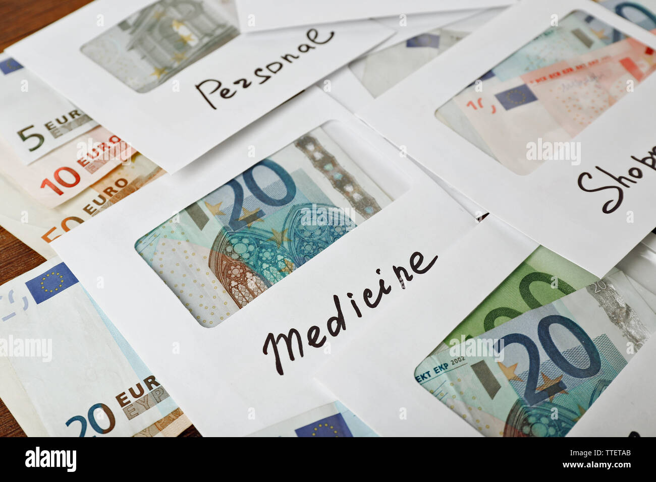 Distribution of money, financial planning, euro in envelopes, on wooden ...