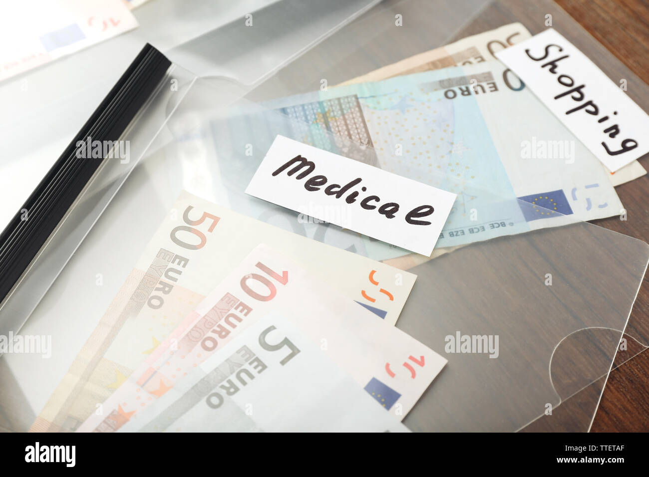 Distribution of money, financial planning, euro in envelopes, on wooden ...