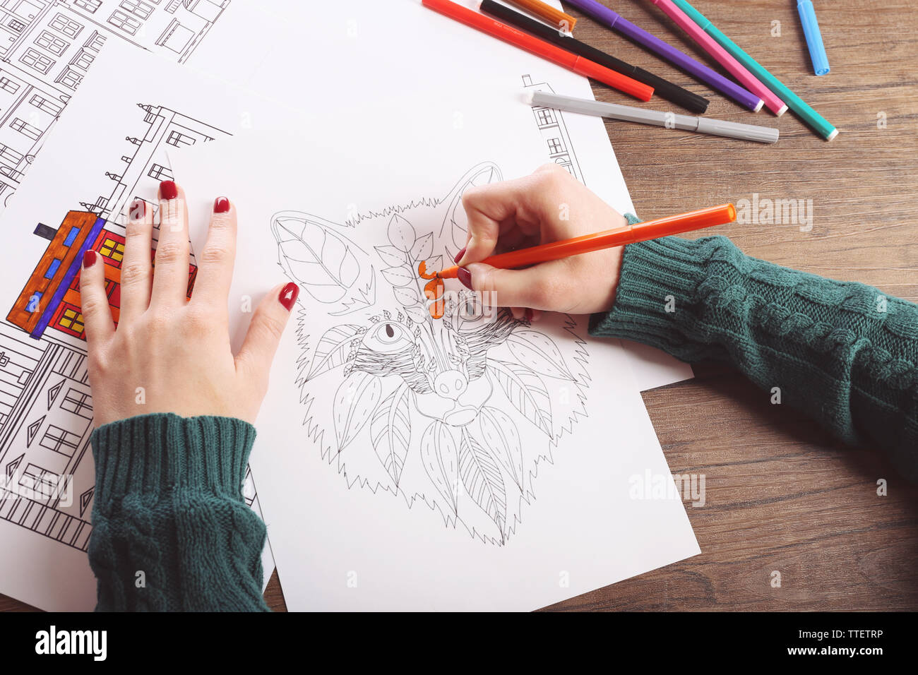 Female hand painting anti stress colouring with orange felt pen Stock ...