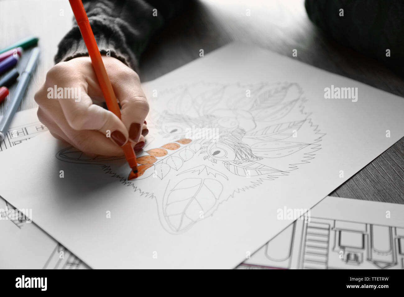 Female hand painting anti stress colouring with orange felt pen Stock ...