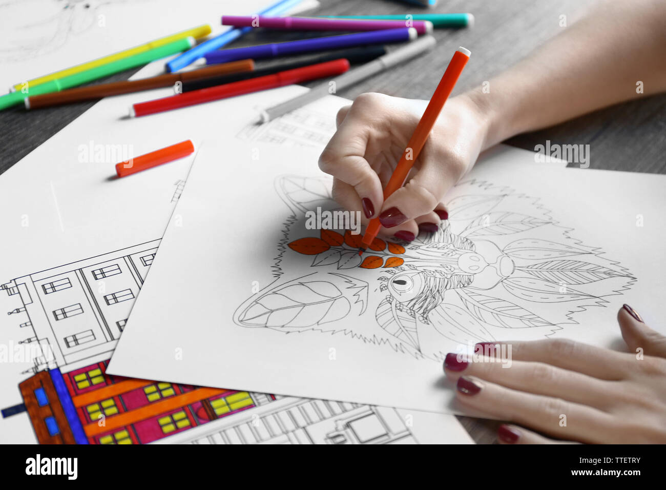 Female hand painting anti stress colouring with orange felt pen Stock ...