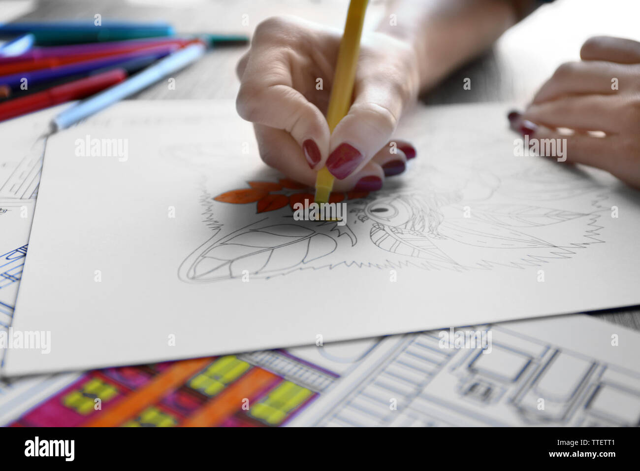 Female hand painting anti stress colouring with yellow felt pen Stock ...