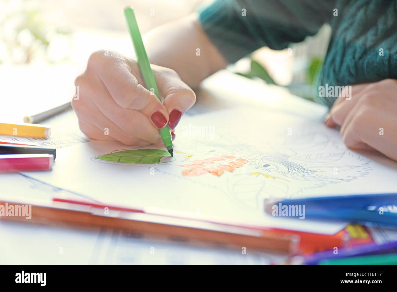 Female hand painting anti stress colouring with green felt pen Stock ...