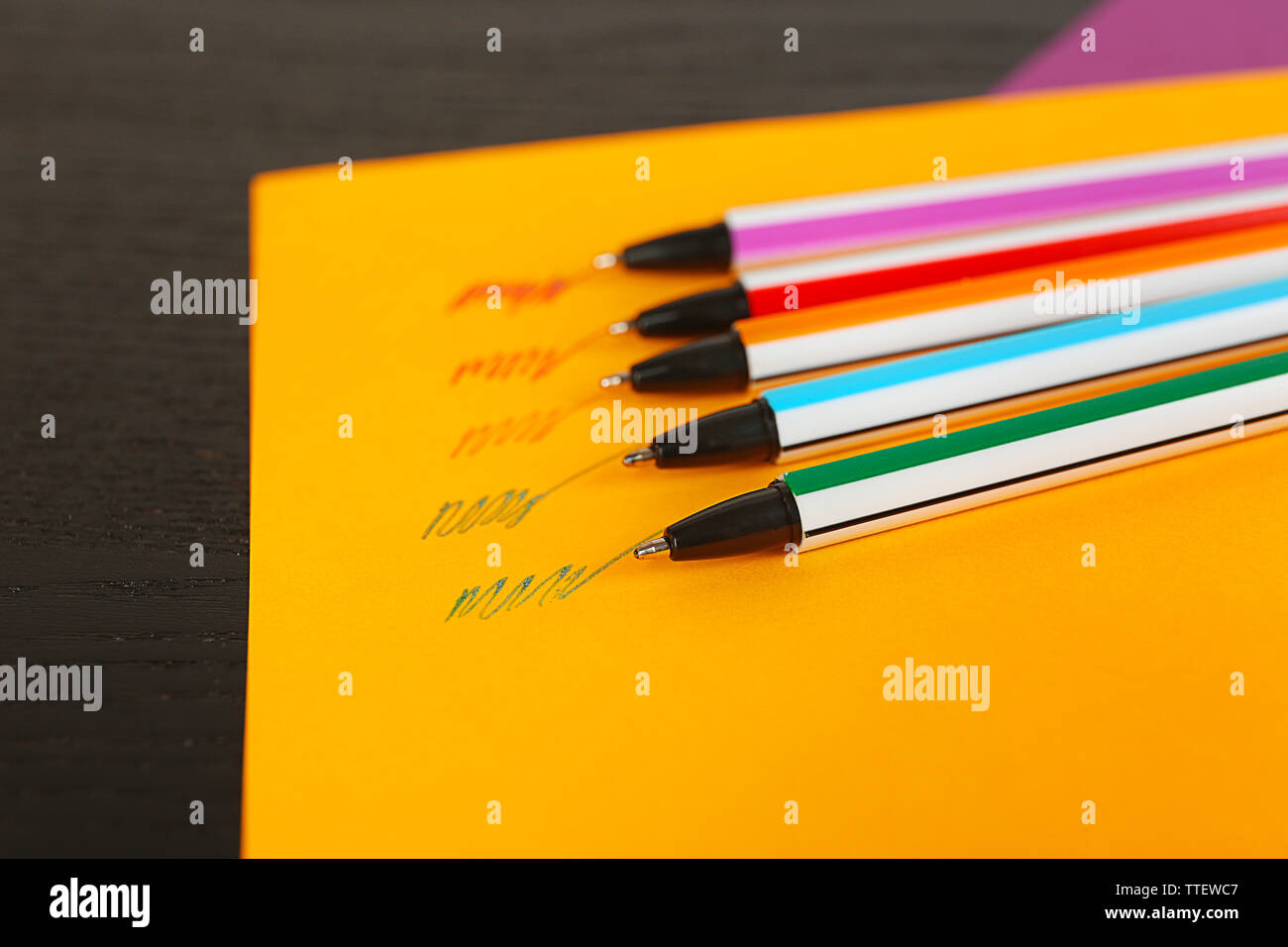 Set of colored pens on paper background Stock Photo - Alamy
