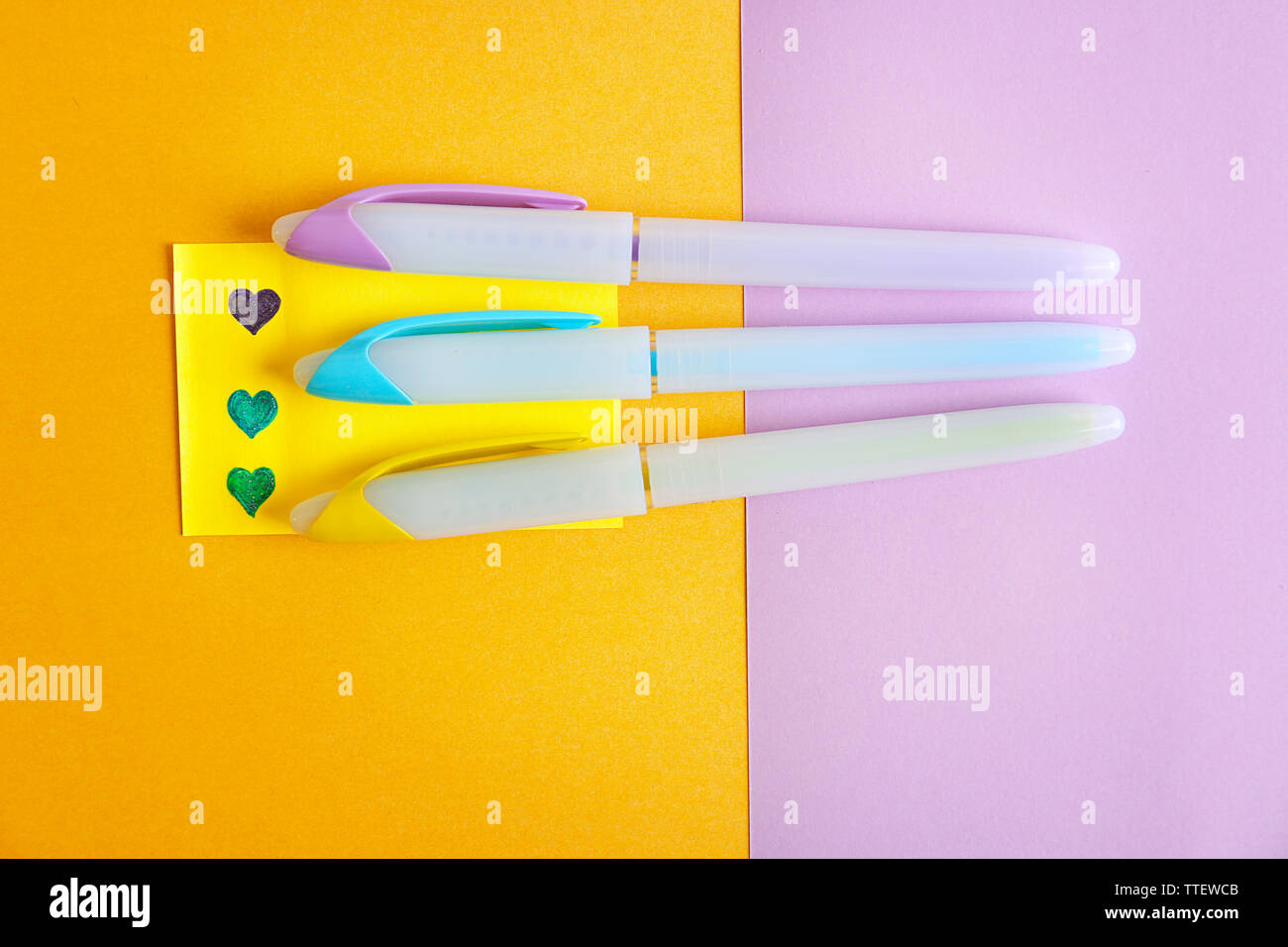 Set of colored pens on yellow paper Stock Photo - Alamy