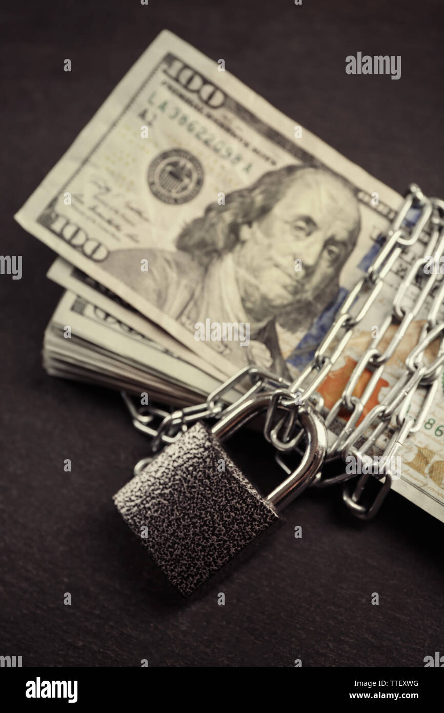 Dollars currency with lock and chain on grey background Stock Photo - Alamy