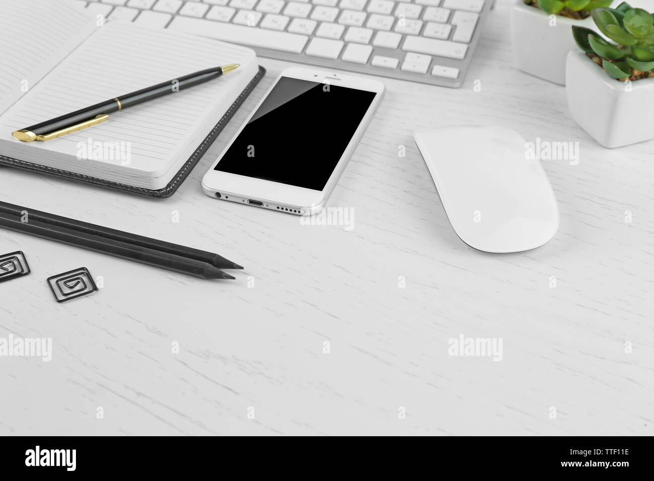 Workplace with mobile phone, computer peripherals and stationery on ...