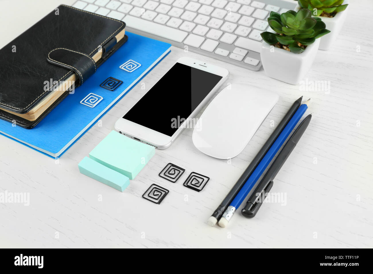 Workplace with mobile phone, computer peripherals and stationery on ...