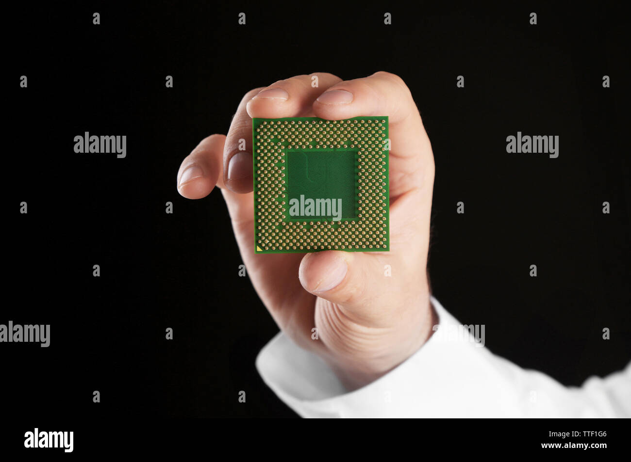 Male hand holding microprocessor on black background Stock Photo - Alamy
