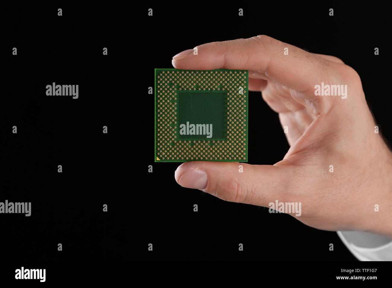 Male hand holding microprocessor on black background Stock Photo - Alamy