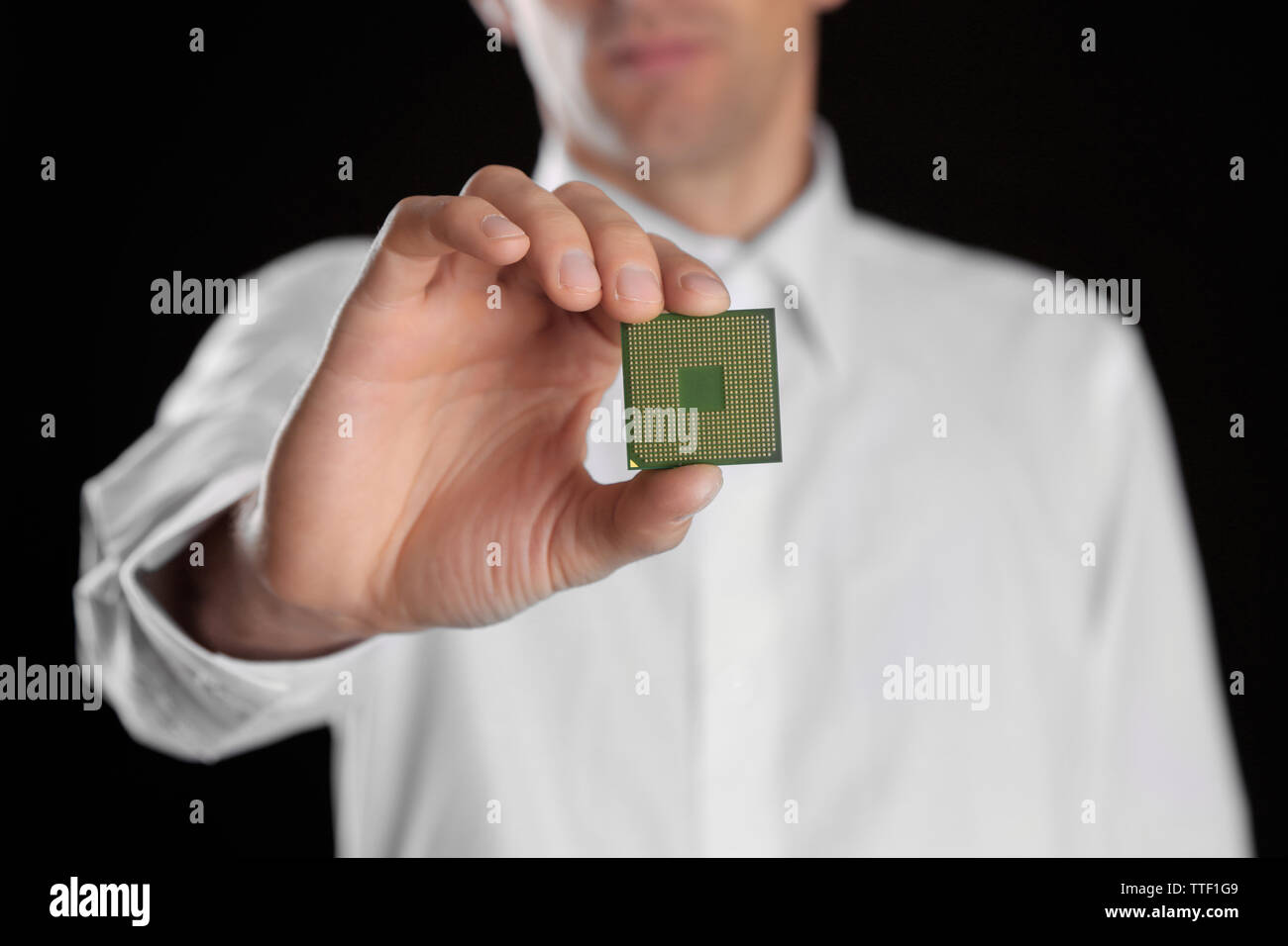 Man holding microprocessor in his hand on black background Stock Photo ...