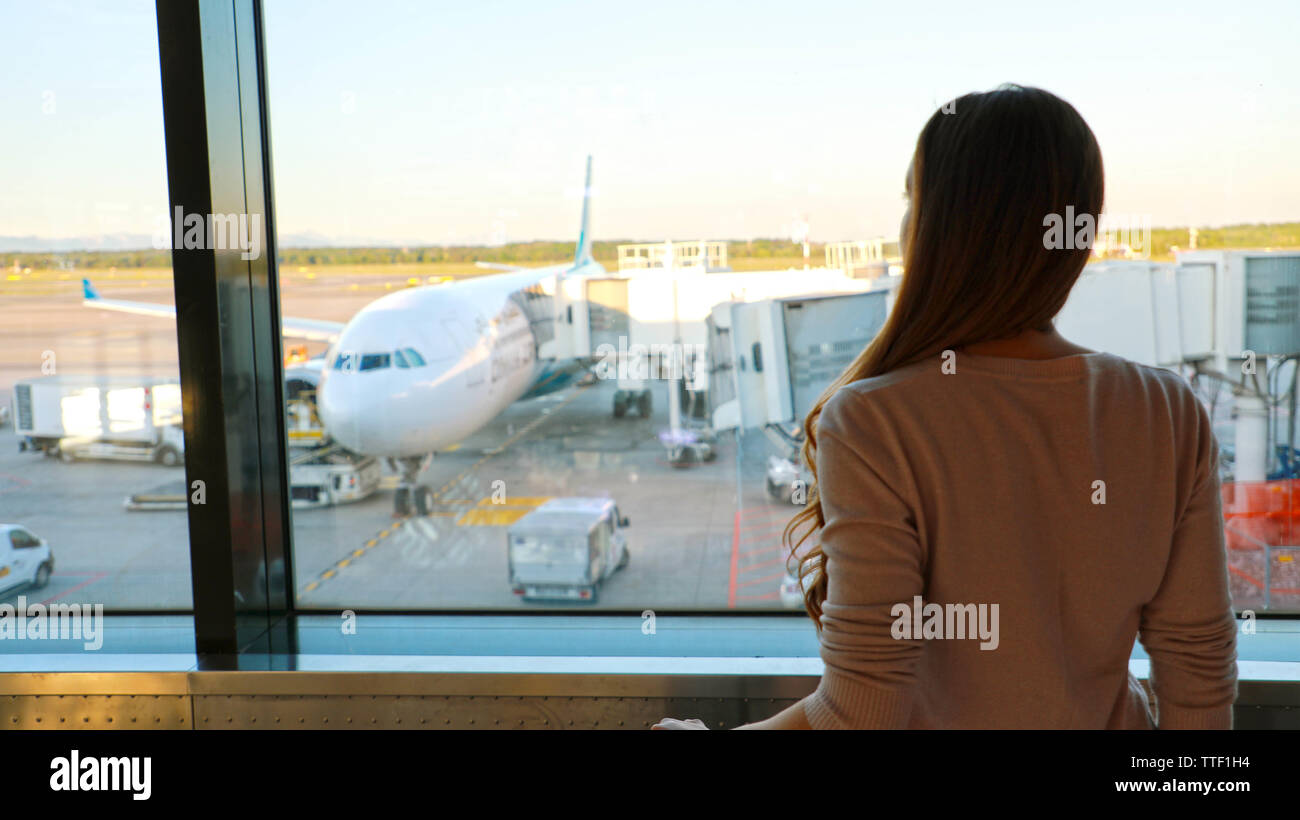 Woman looking through window of plane hi-res stock photography and ...