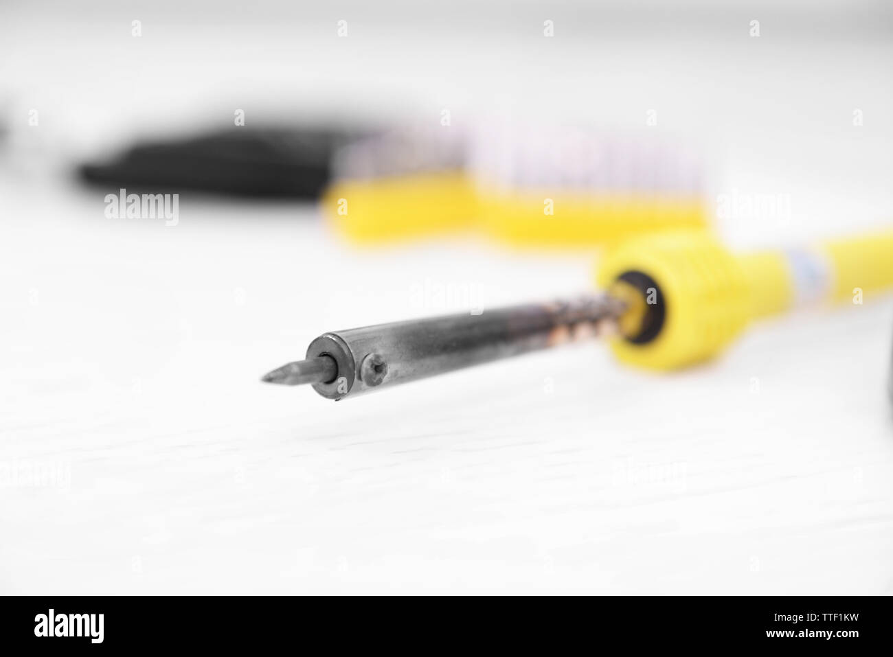 Yellow soldering iron on blurred white background Stock Photo - Alamy