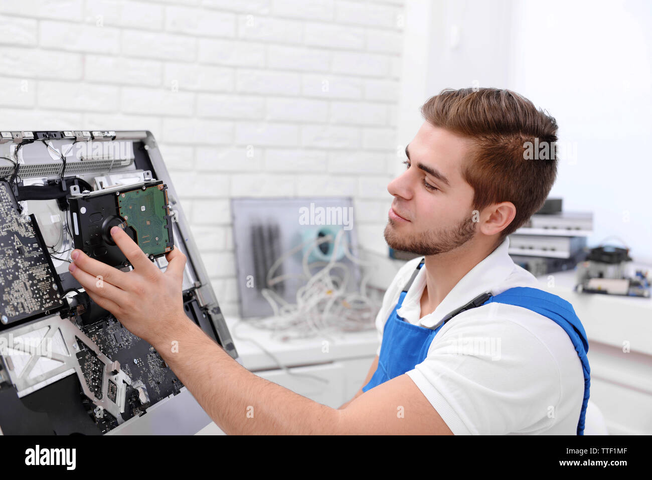 Young repairer disassembling a computer internal parts in service ...