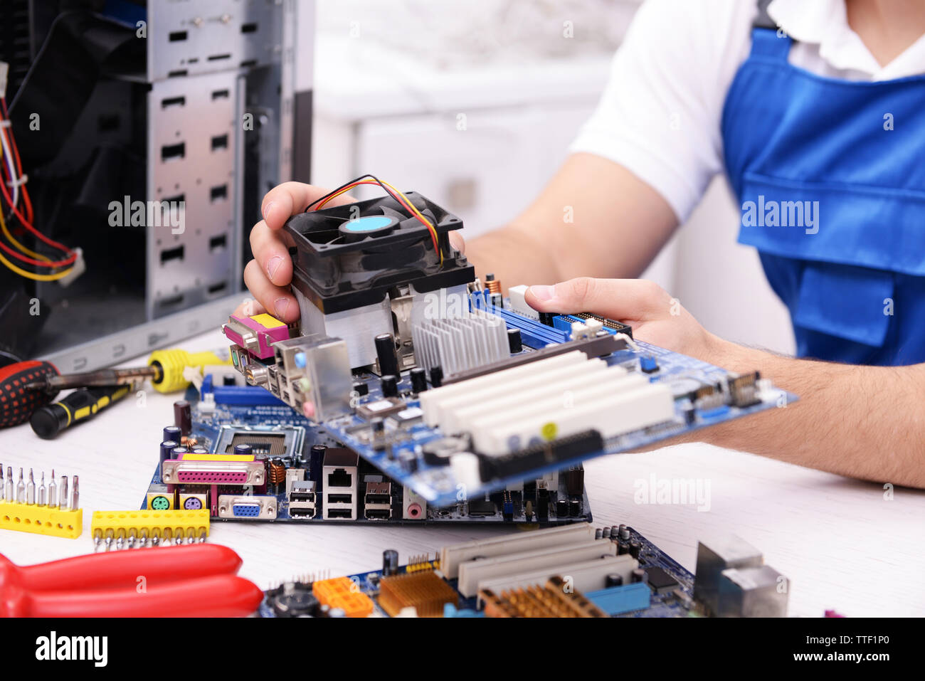 Young repairer disassembling a computer internal parts in service ...