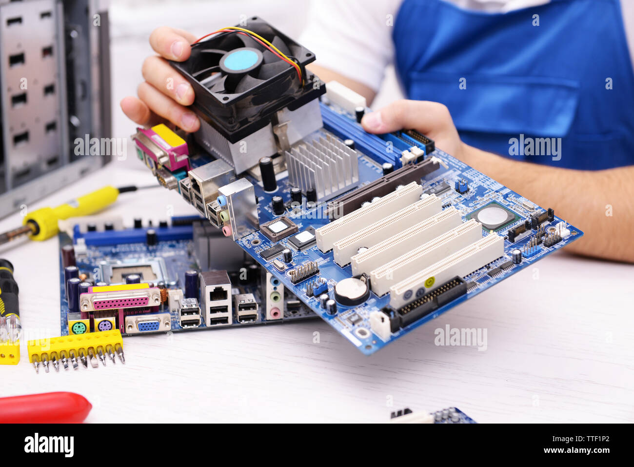 Young repairer disassembling a computer internal parts in service ...