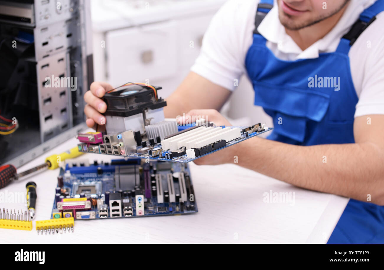 Young repairer disassembling a computer internal parts in service ...