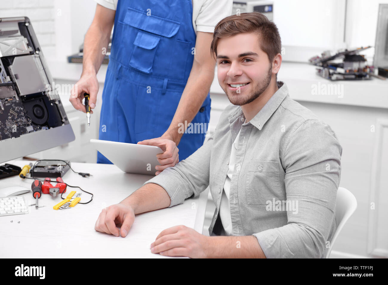 Master showing the repair process to young man in service center Stock ...