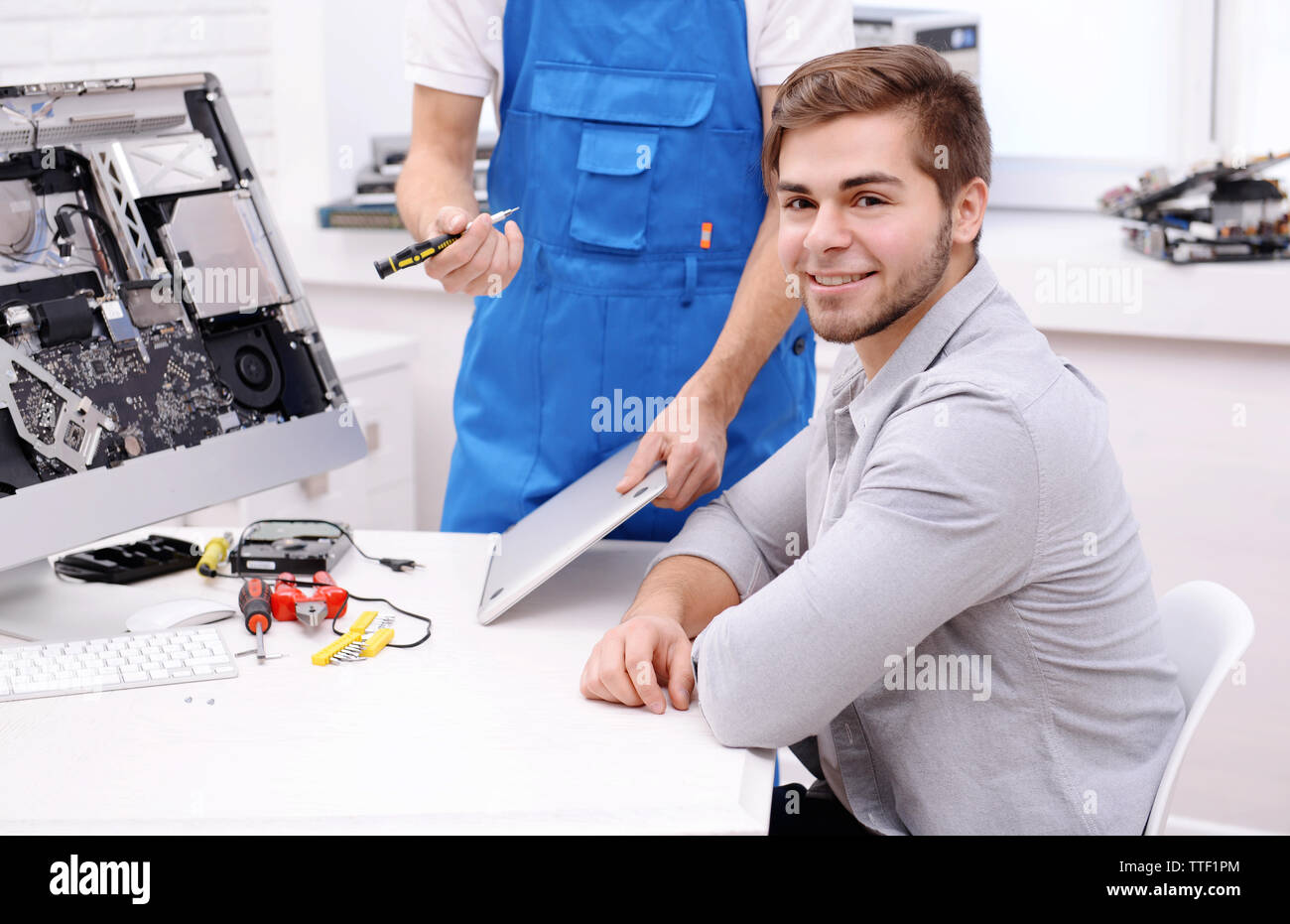 Master showing the repair process to young man in service center Stock ...