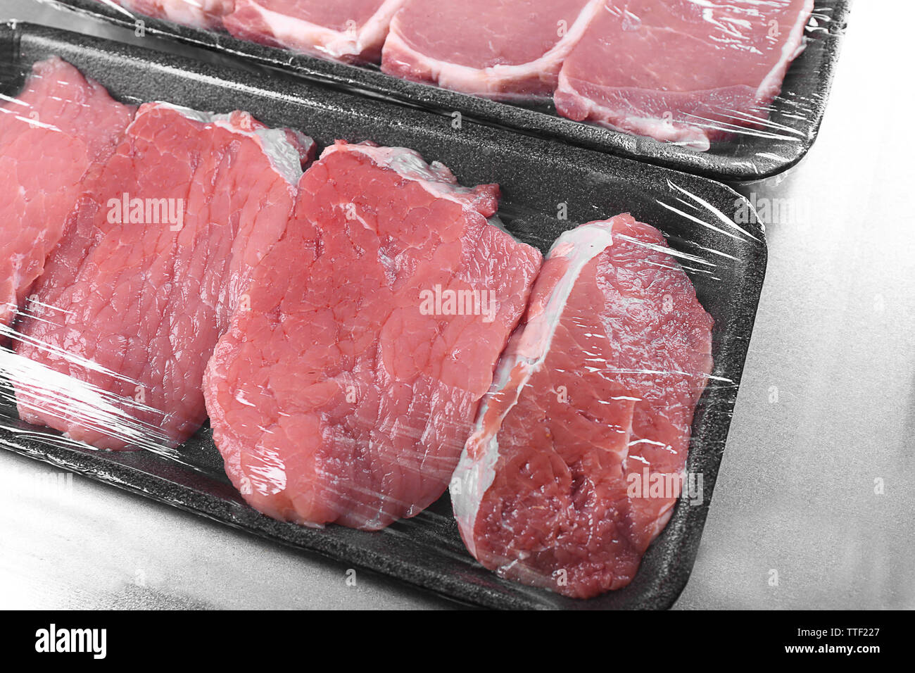 Packed pieces of pork and beef meat on metal background Stock Photo - Alamy