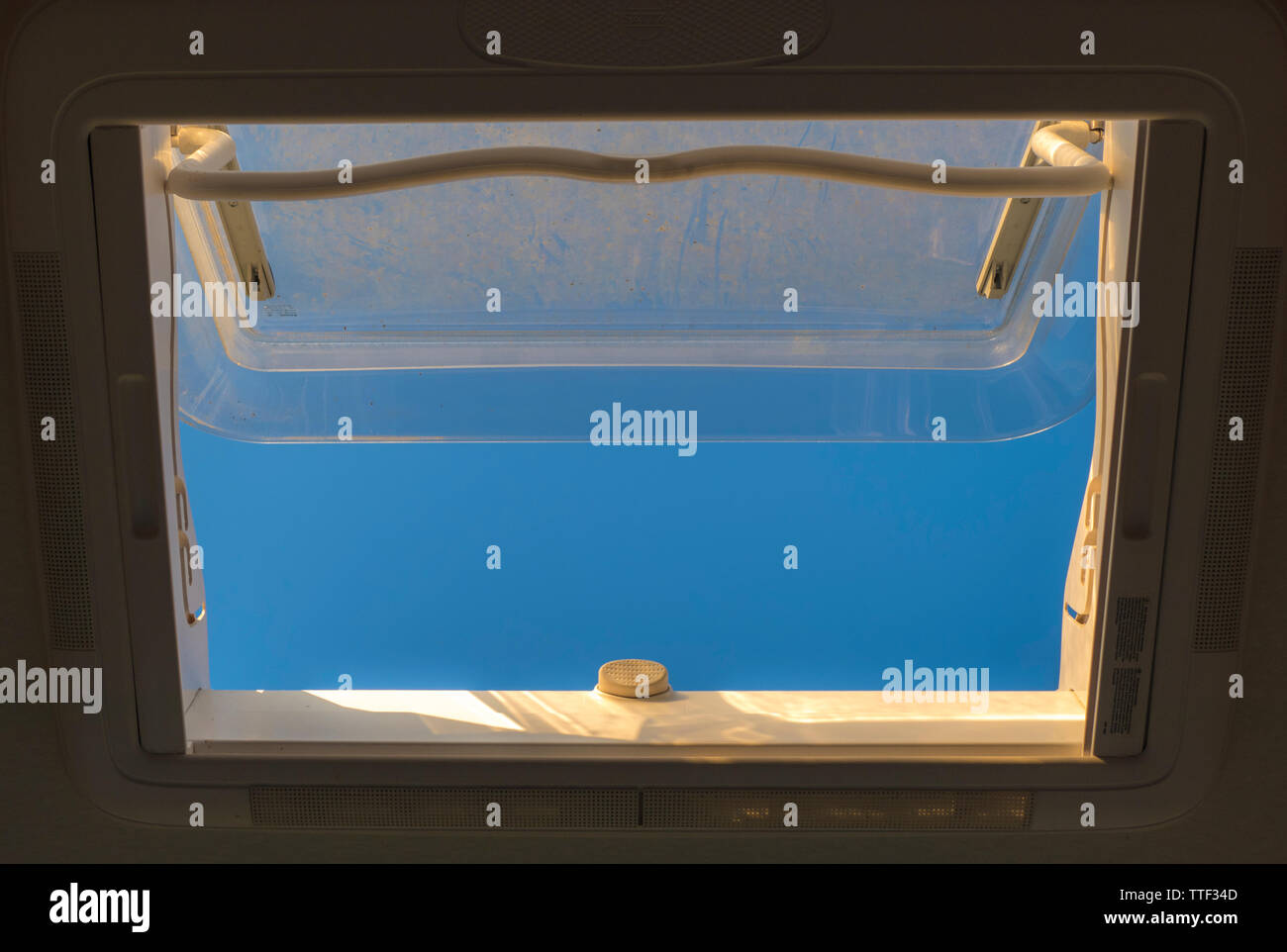 An open caravan / camper / motorhome roof light / vent, against a blue ...