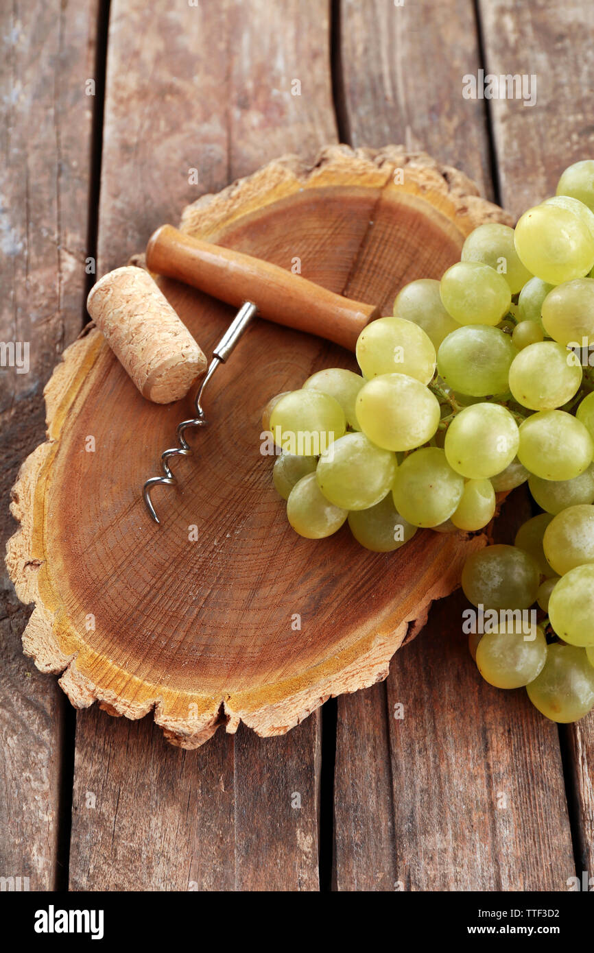 Wine cork and tailspin with bunch of grapes on wooden background Stock ...