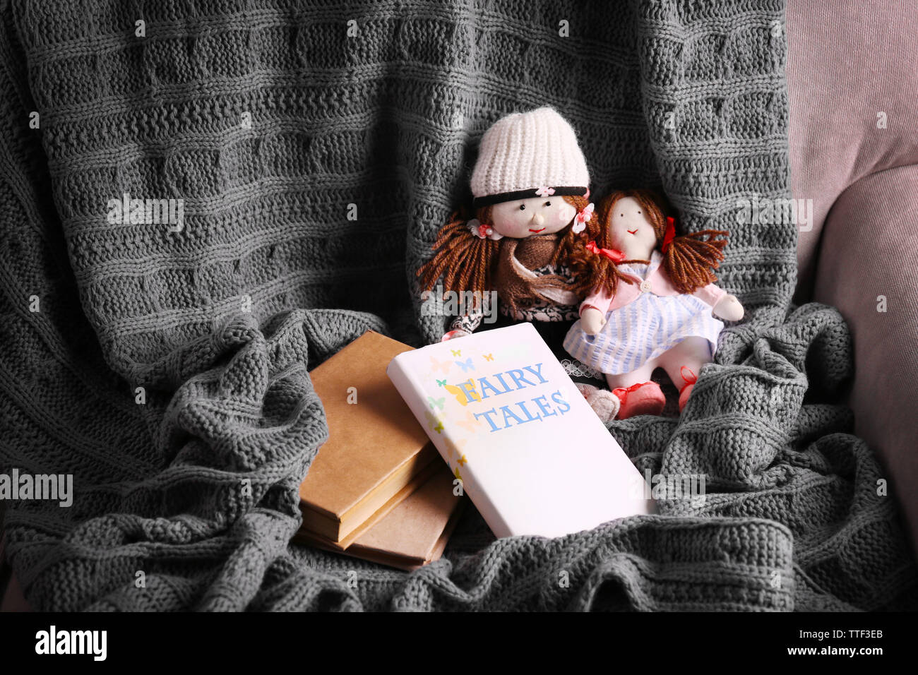 Rag dolls with fairy tales books on bedspread. Childhood concept Stock ...