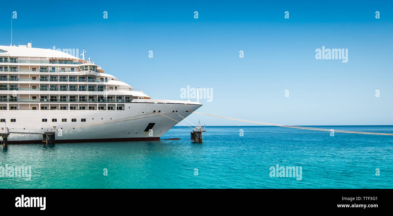 Side view and bow of a docked cruise ship on a summer day with clear ...