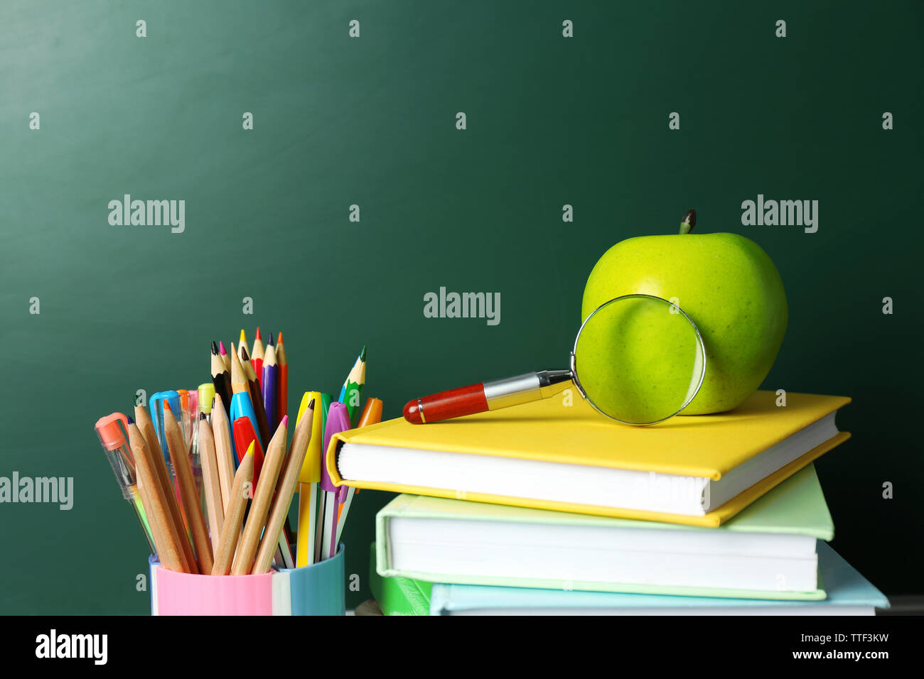 School books on desk near chalkboard Stock Photo - Alamy