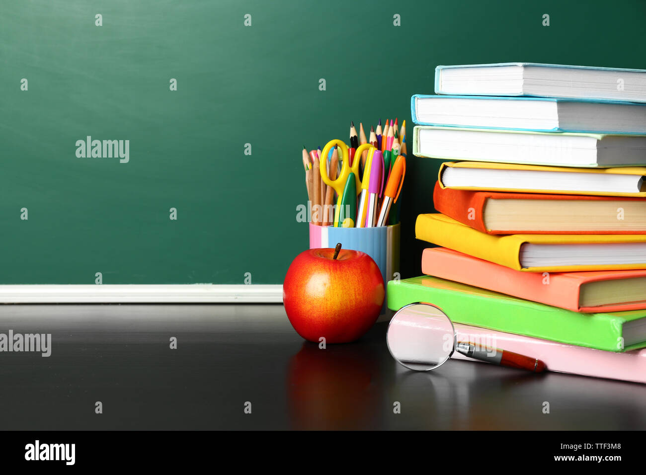 School books on desk near chalkboard Stock Photo - Alamy