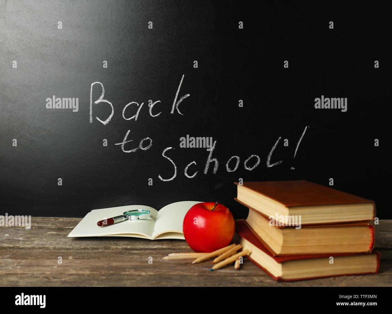 School books on desk near chalkboard Stock Photo - Alamy