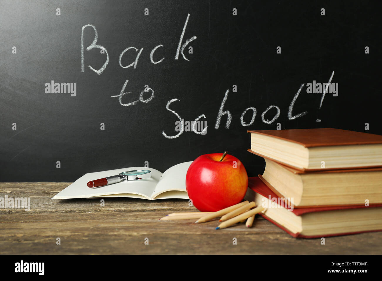 School books on desk near chalkboard Stock Photo - Alamy