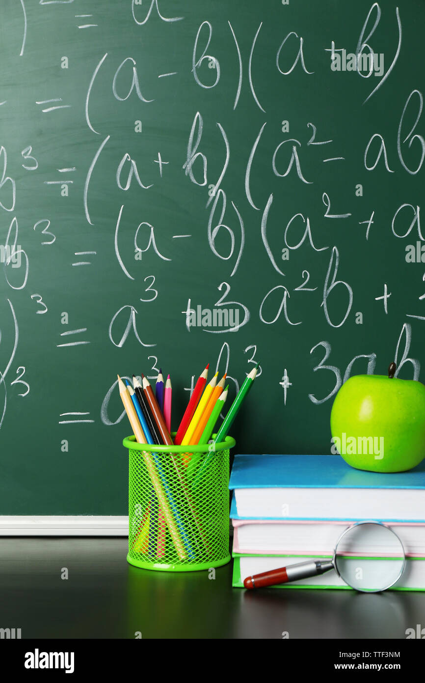 School books on desk near chalkboard Stock Photo - Alamy