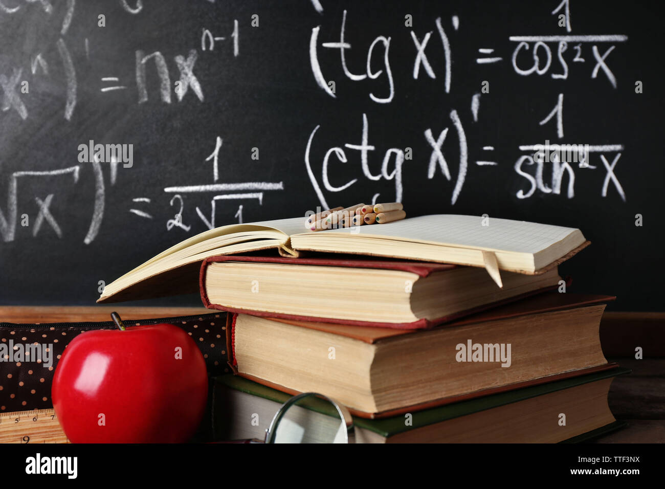 School books on desk near chalkboard Stock Photo - Alamy