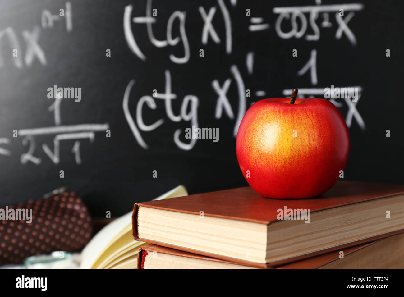 School books on desk near chalkboard Stock Photo - Alamy