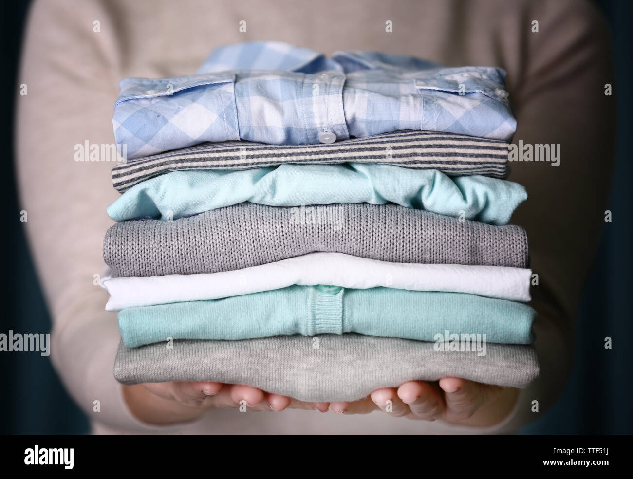 Woman holding washed and dried clothes on curtain background Stock ...