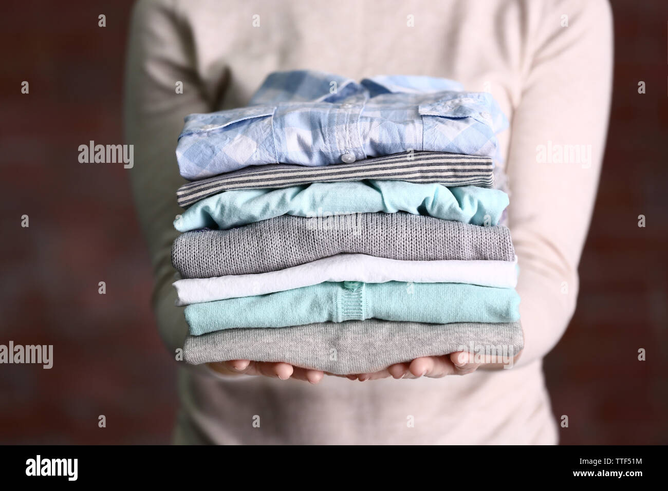 Woman holding washed and dried clothes on dark background Stock Photo ...