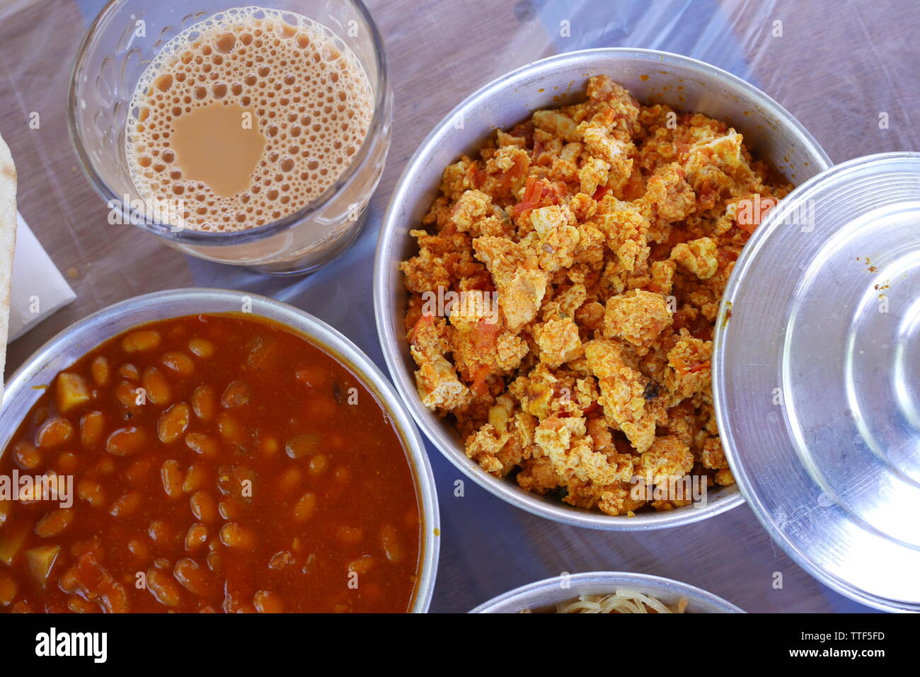 Bahrain breakfast of beans, scrambled eggs and karak tea, in metal ...