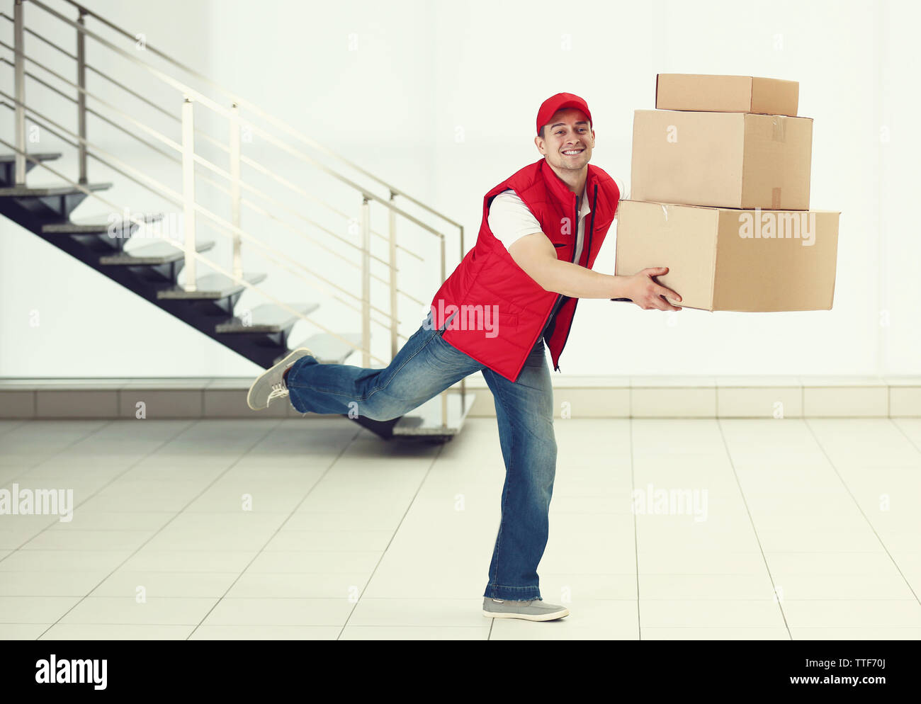 Man holding pile of carton boxes in the room Stock Photo - Alamy