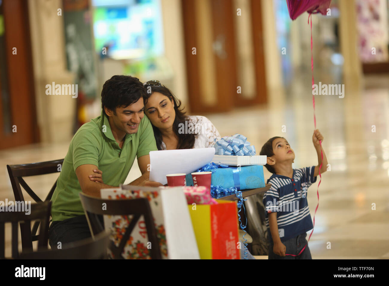 Family with gifts in a shopping mall Stock Photo - Alamy
