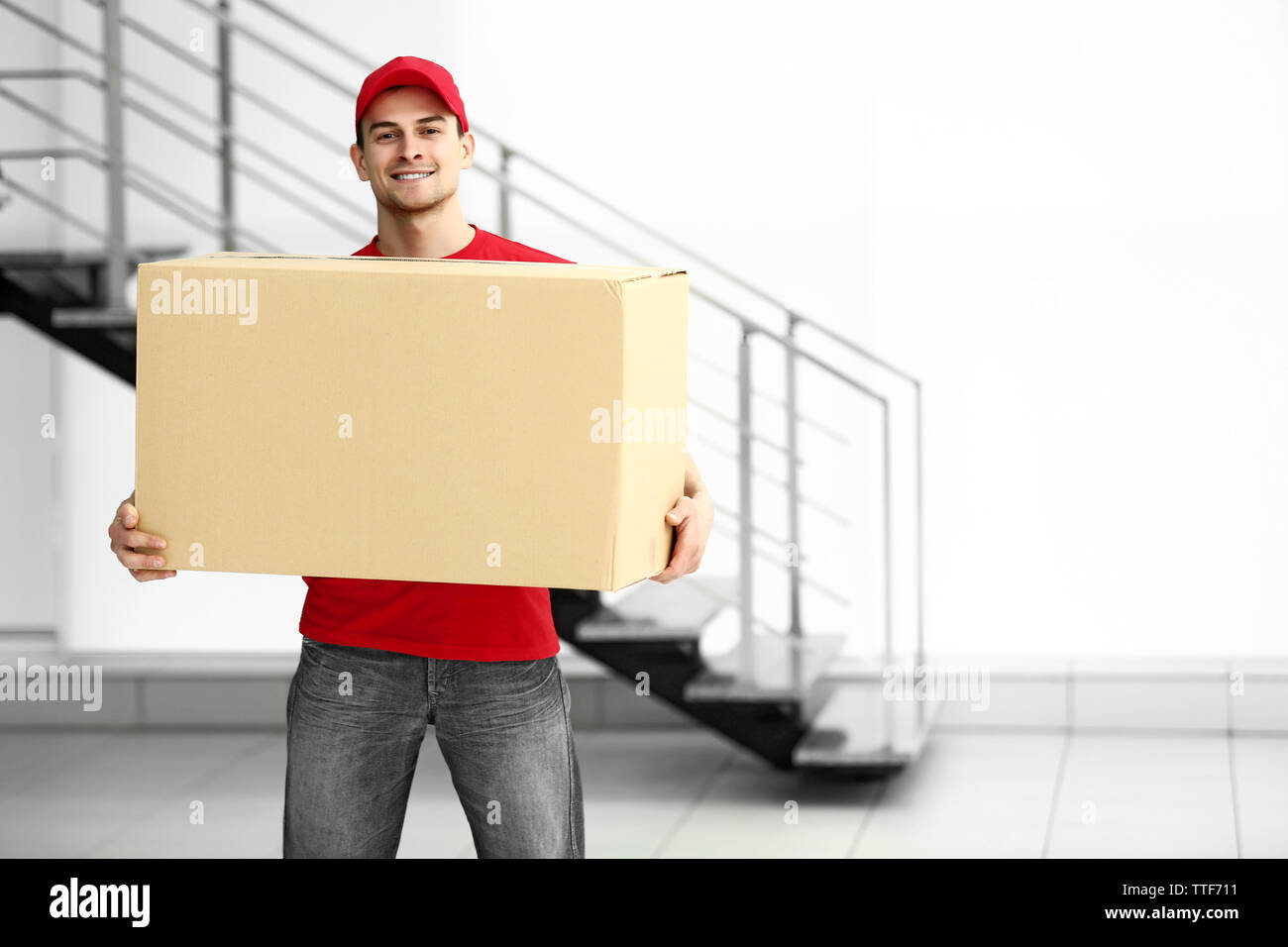 Man holding carton box in the room Stock Photo - Alamy
