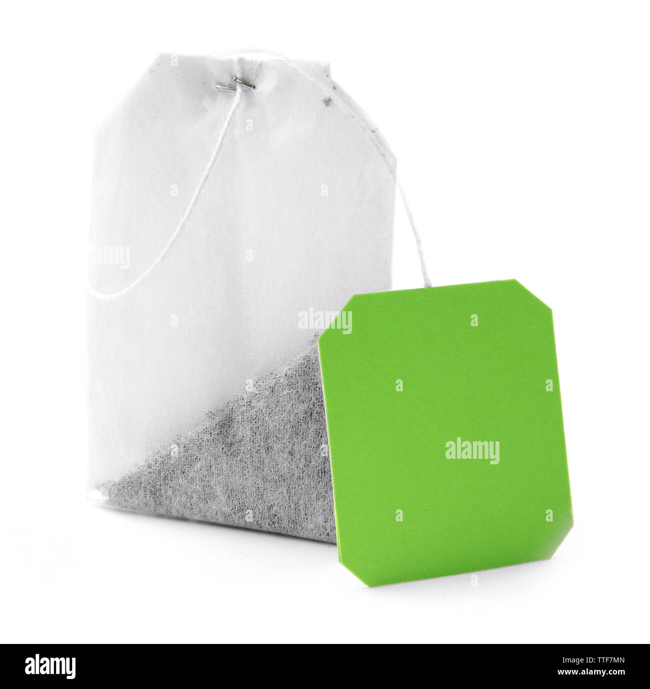 Tea bag with green label, isolated on white Stock Photo - Alamy