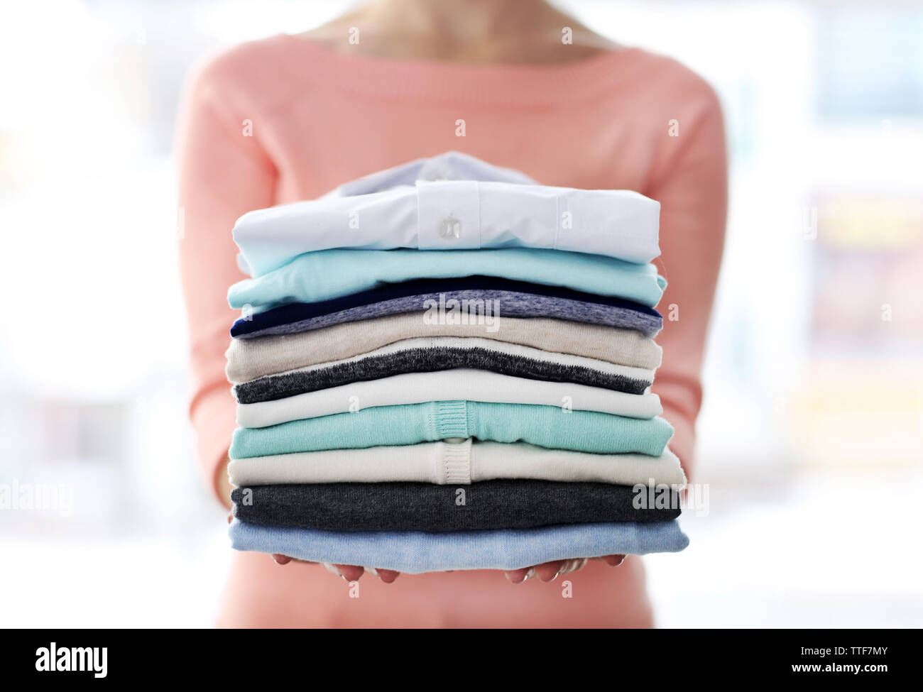 Woman hold clothes pile, close up Stock Photo - Alamy