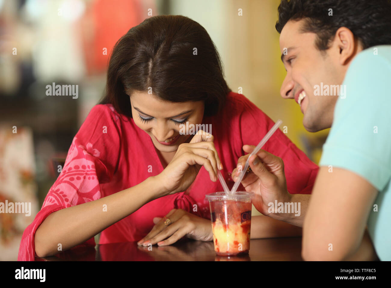 Couple sharing a drink in a cafe Stock Photo - Alamy